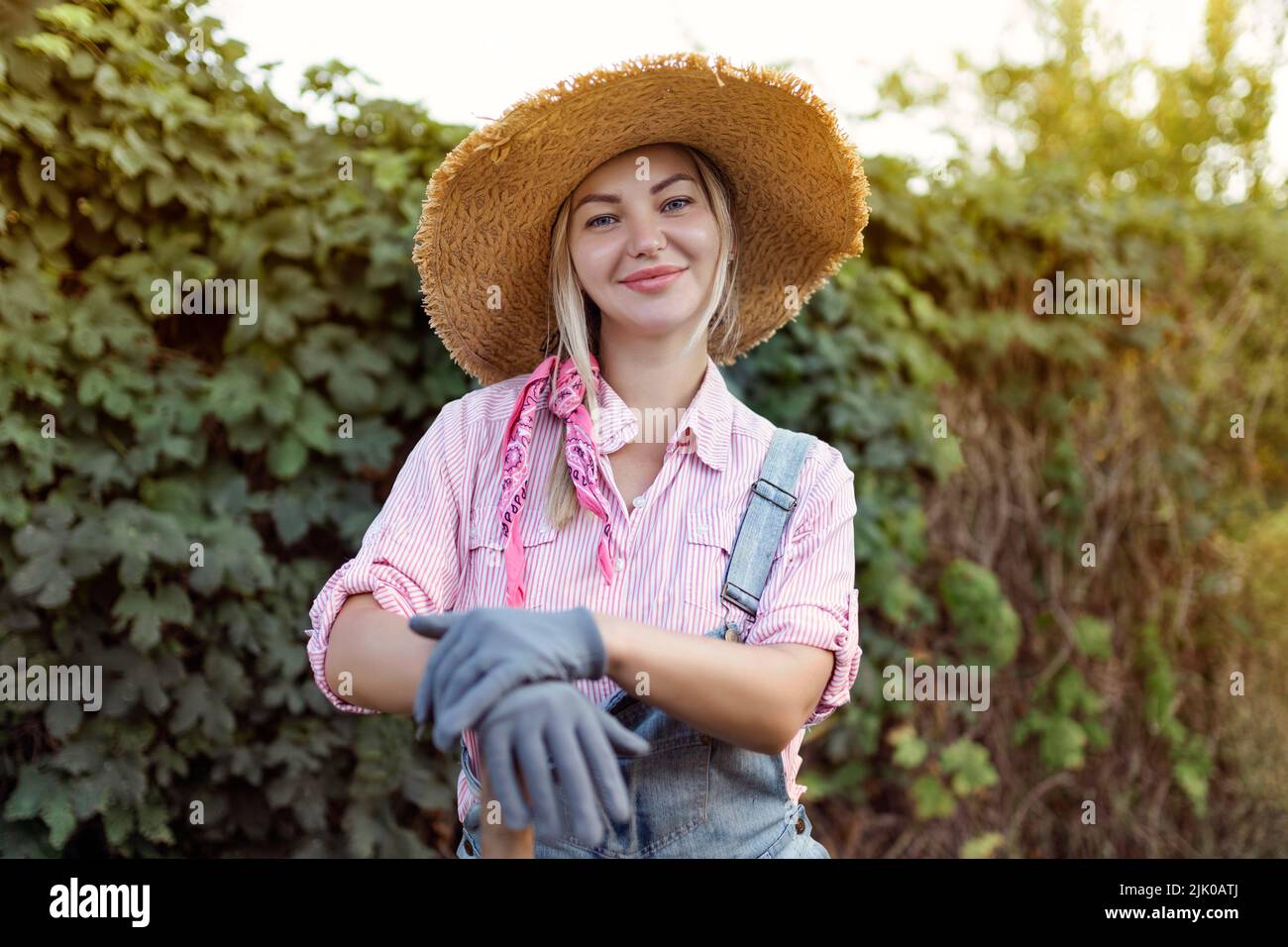 Beautiful young woman gardening outside in summer nature Stock Photo ...