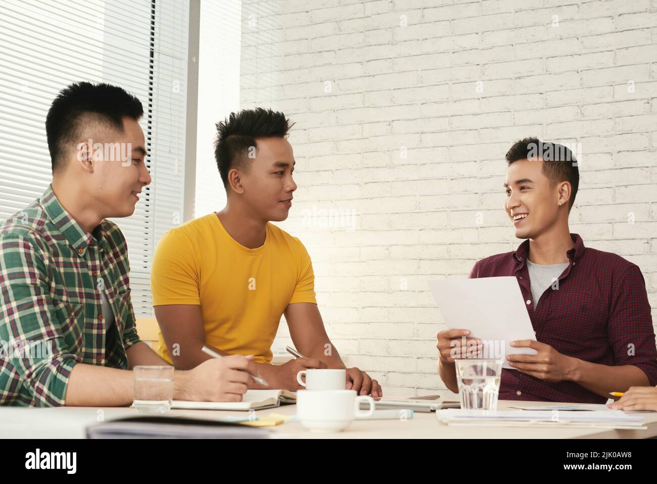 Group of creative young people discussing ideas for start-up project ...