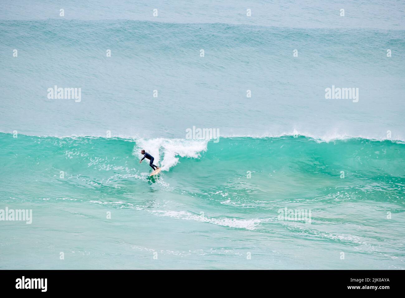 A surfer rides a surf wave of the Atlantic sea at the Great Western ...