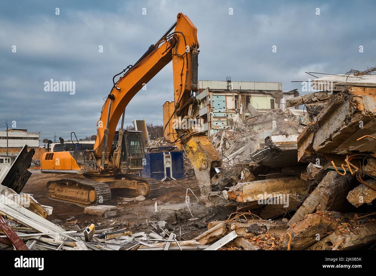 Excavator destroyer with hydraulic scissors cuts concrete Stock Photo ...