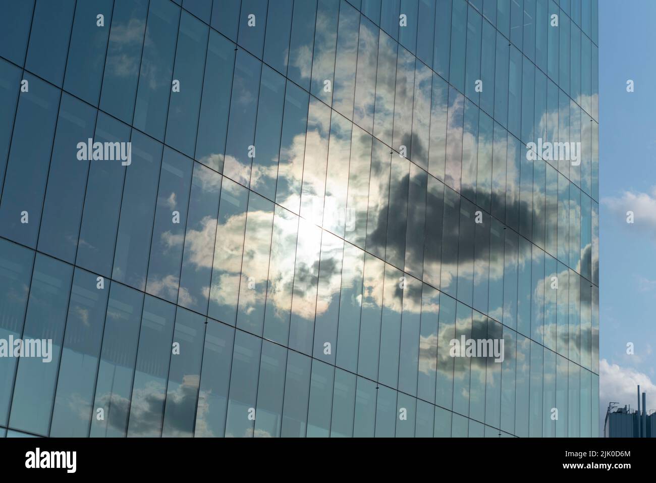 The bright blue cloudy sky reflected in the transparent glass windows ...