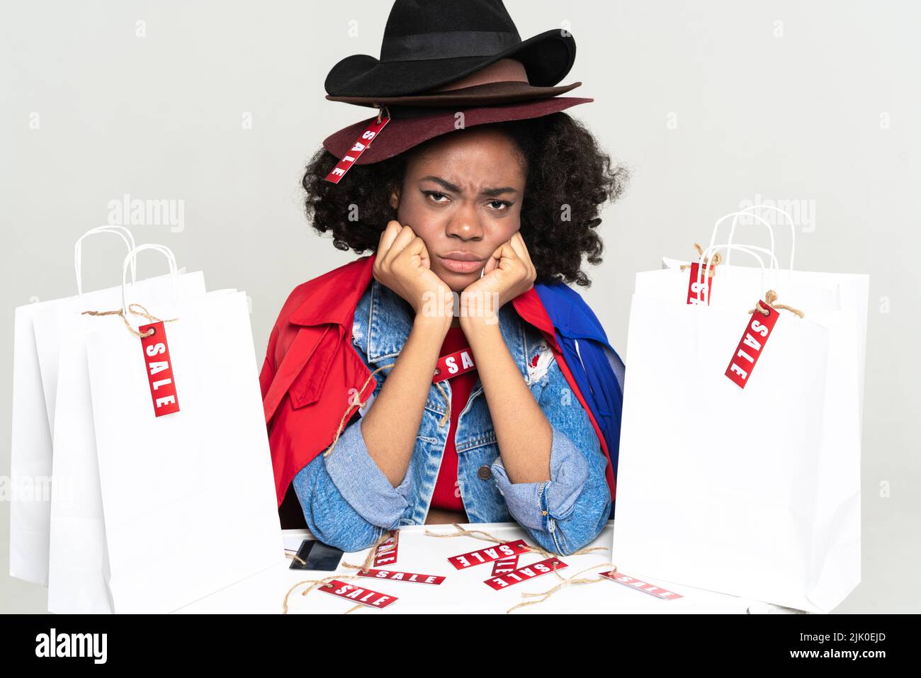 Black young woman frowning while posing with shopping bags isolated ...