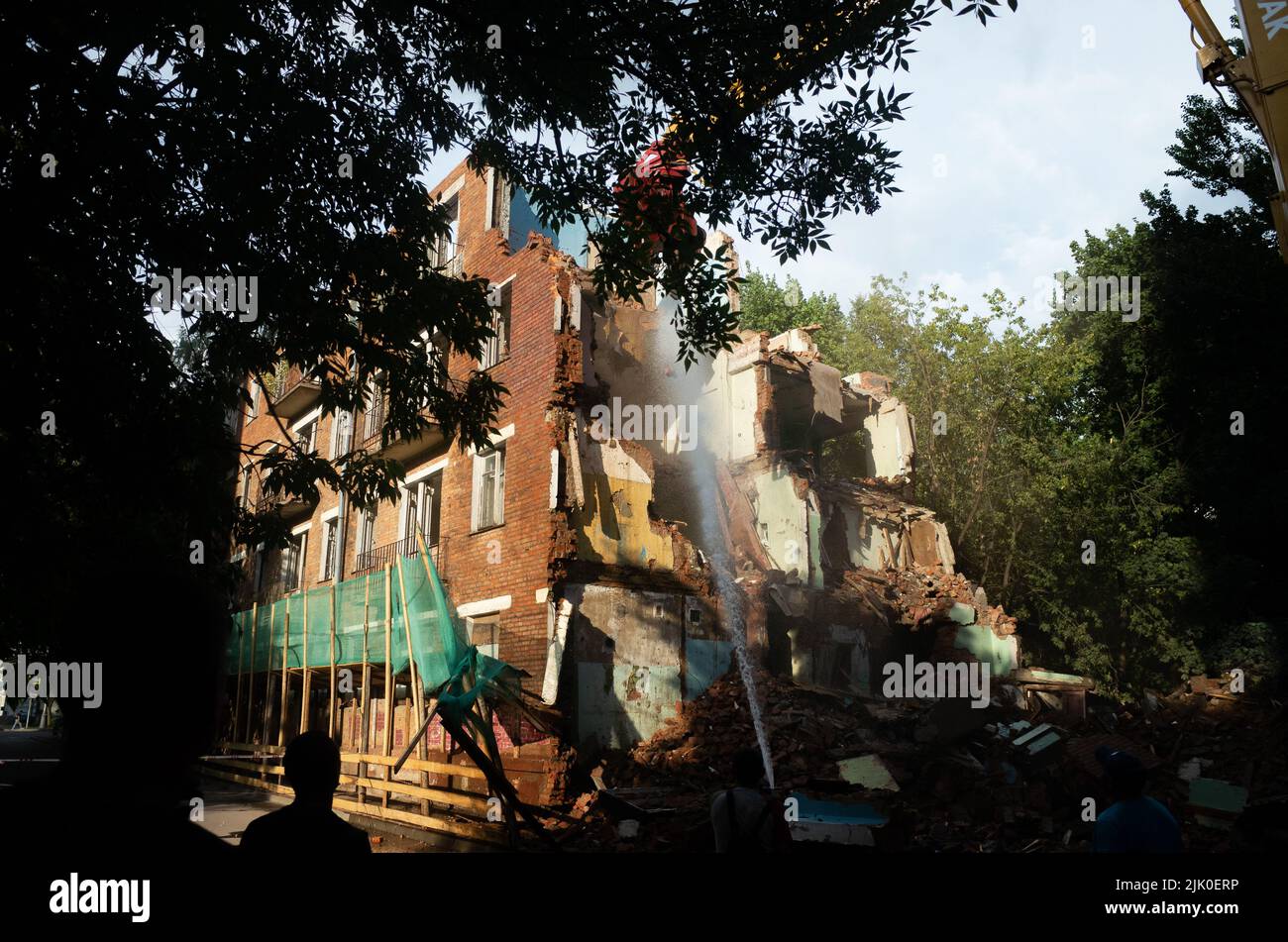 Demolition of a brick building with excavator mechanical arm ...