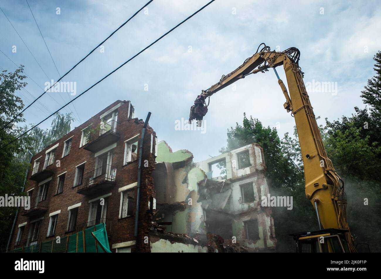 Demolition of a brick building with excavator mechanical arm ...