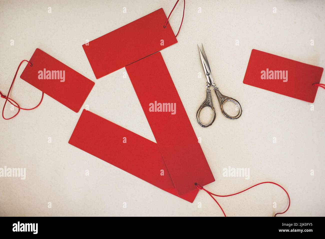 Red tags and scissors lie on a white background Stock Photo - Alamy