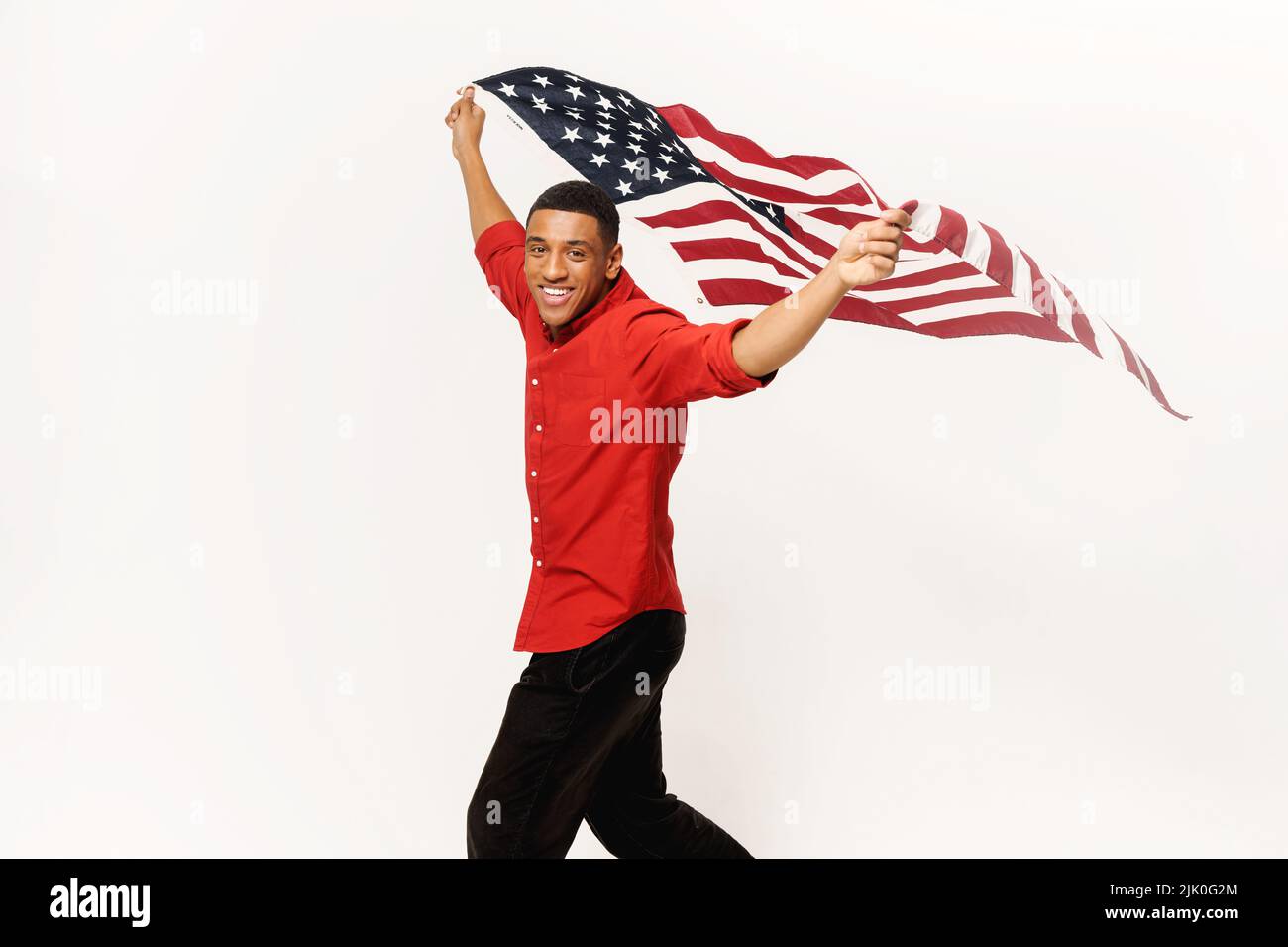 Cheerful African-American guy holding in hands american flag and ...