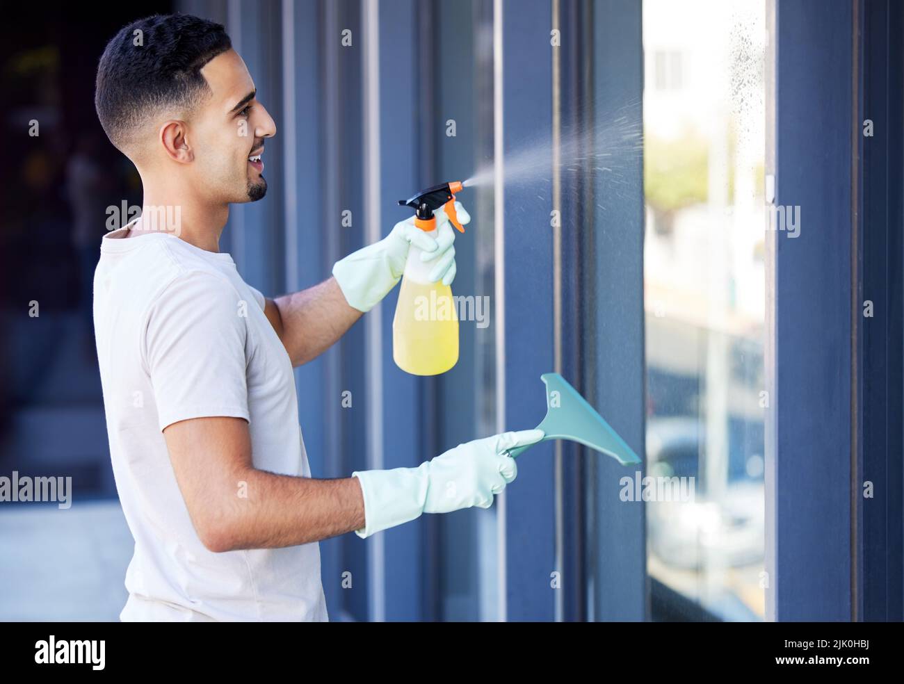 Have to have clean windows. a young man washing windows at home Stock ...