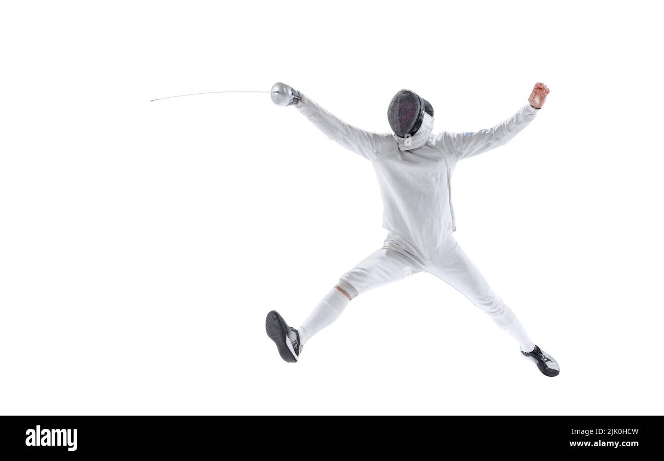 Dynamic portrait of young man, fencer in in fencing costume with sword ...