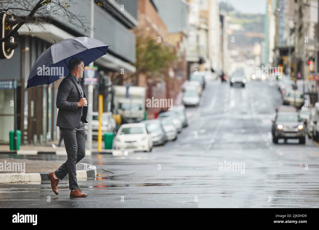 My city is beautiful on rainy days. a handsome businessman walking to ...