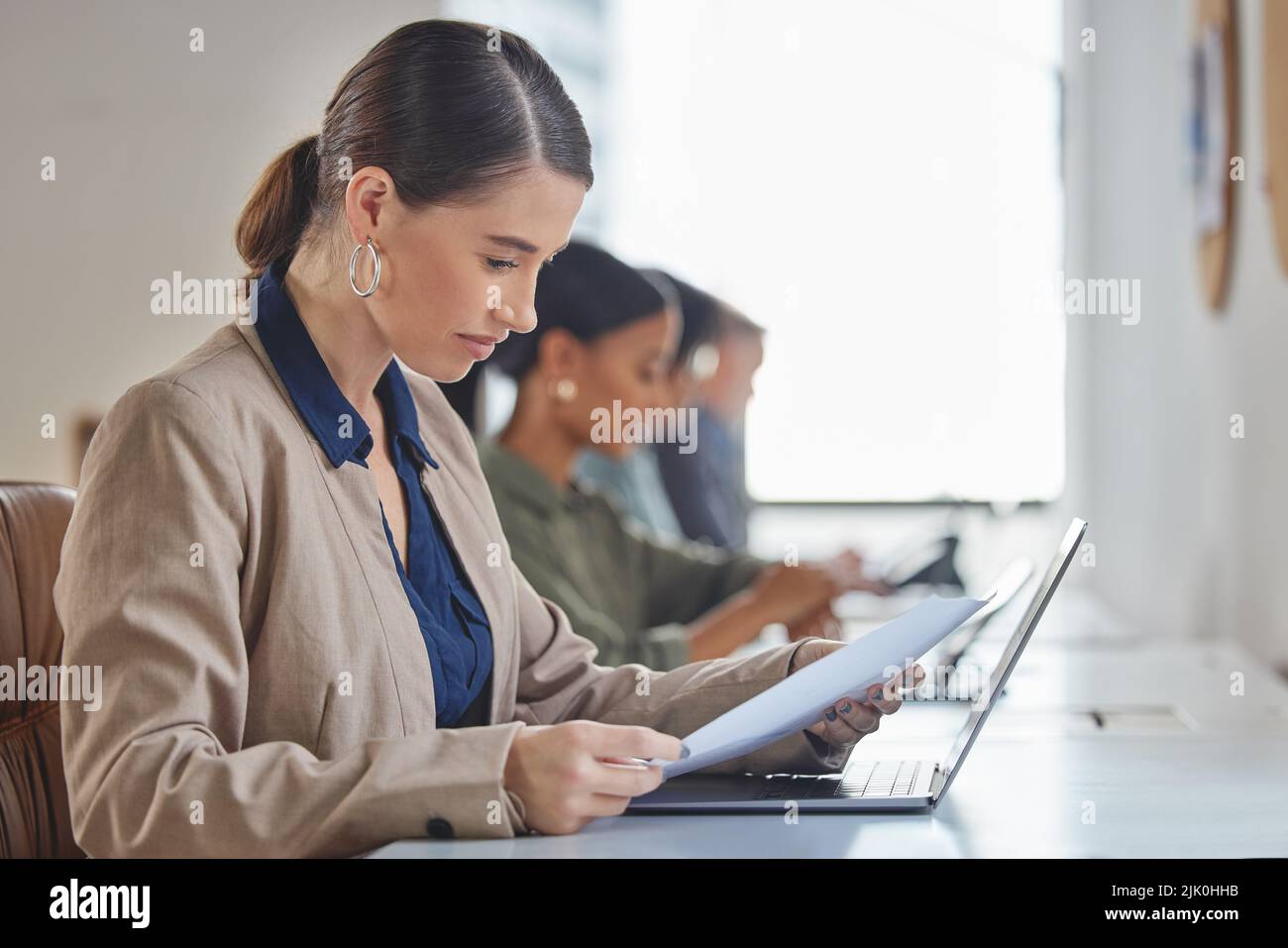 Taking note of her monthly targets. a young businesswoman going through ...