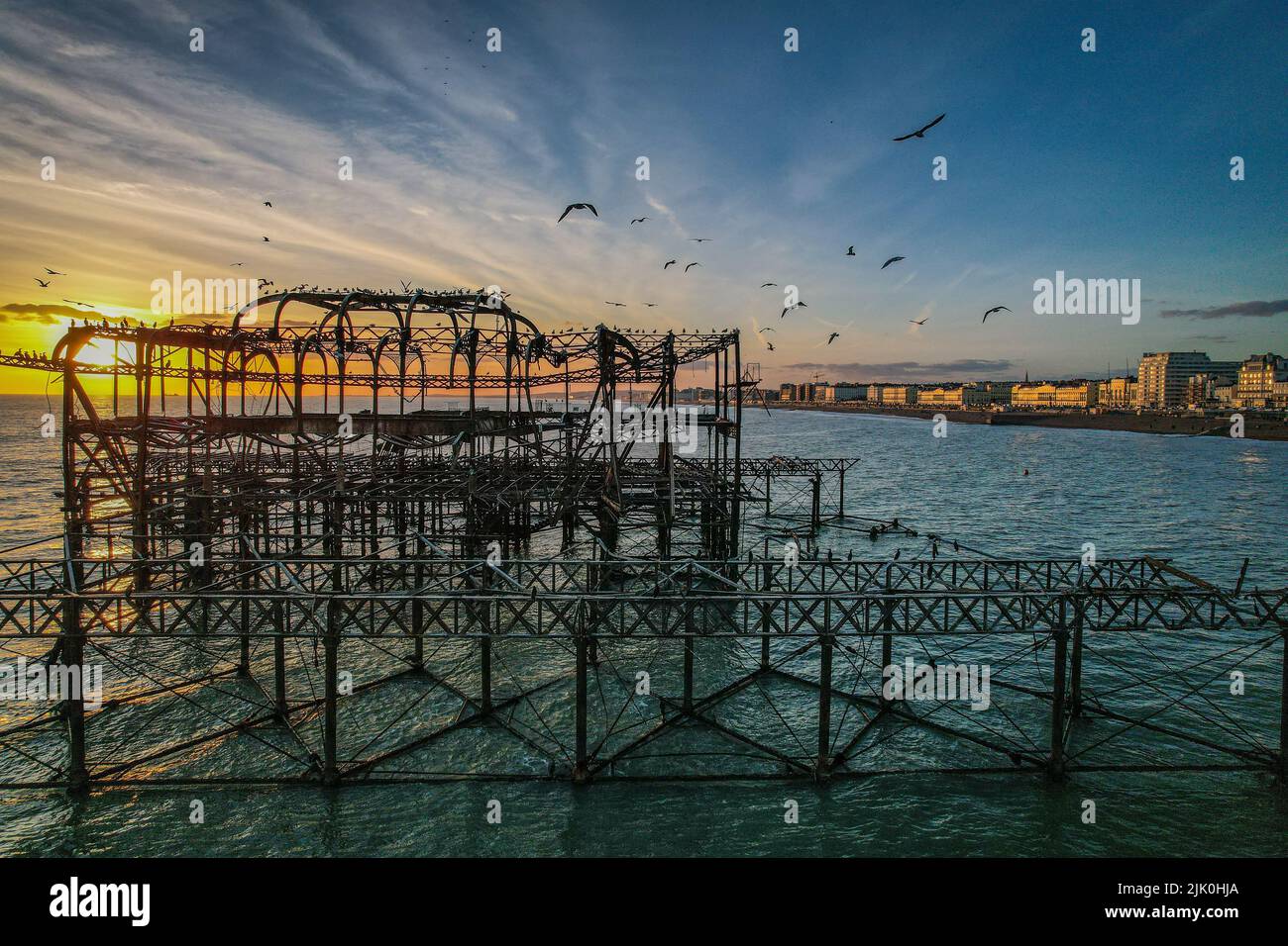 A scenic view of a metal pier structure in the ocean in a colorful ...