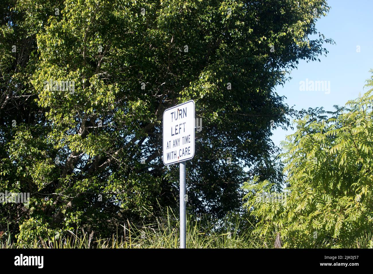 Road sign "Turn Left at Any Time with Caution". Gold Coast, Australia ...
