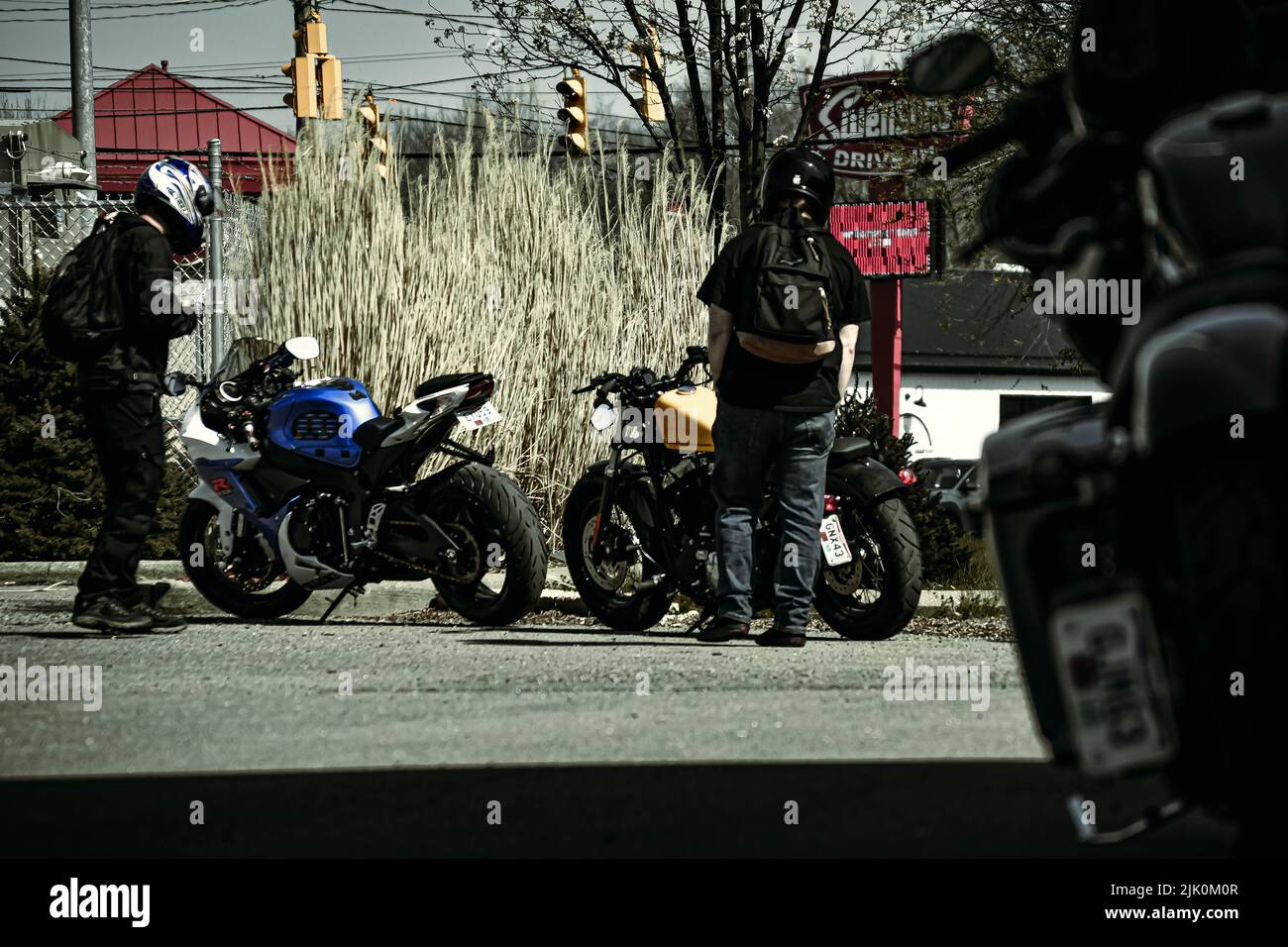 Two bikers standing next to motorcycles Stock Photo - Alamy