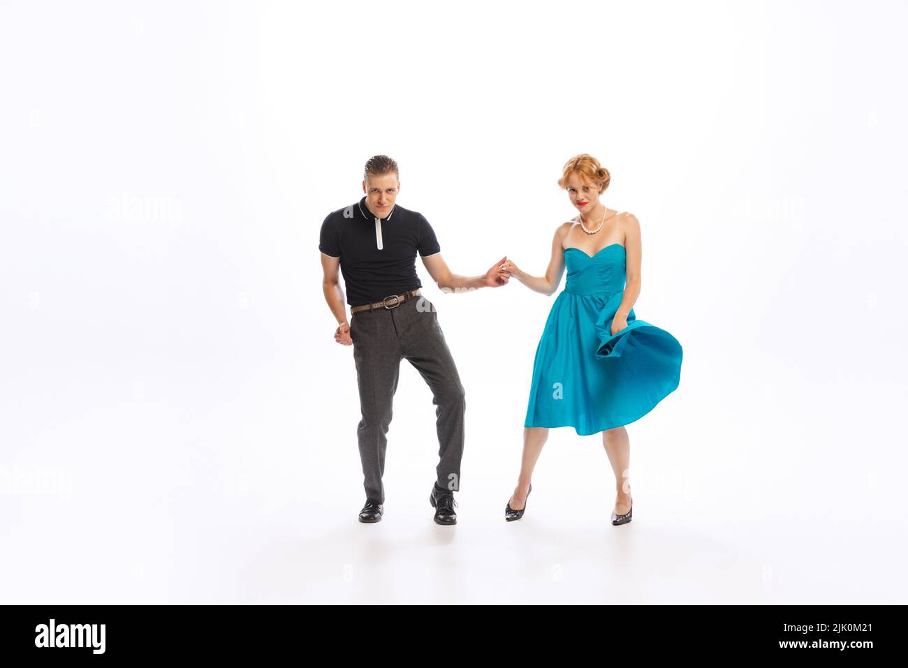 Portrait of stylish young couple, man and woman dancing isolated over ...