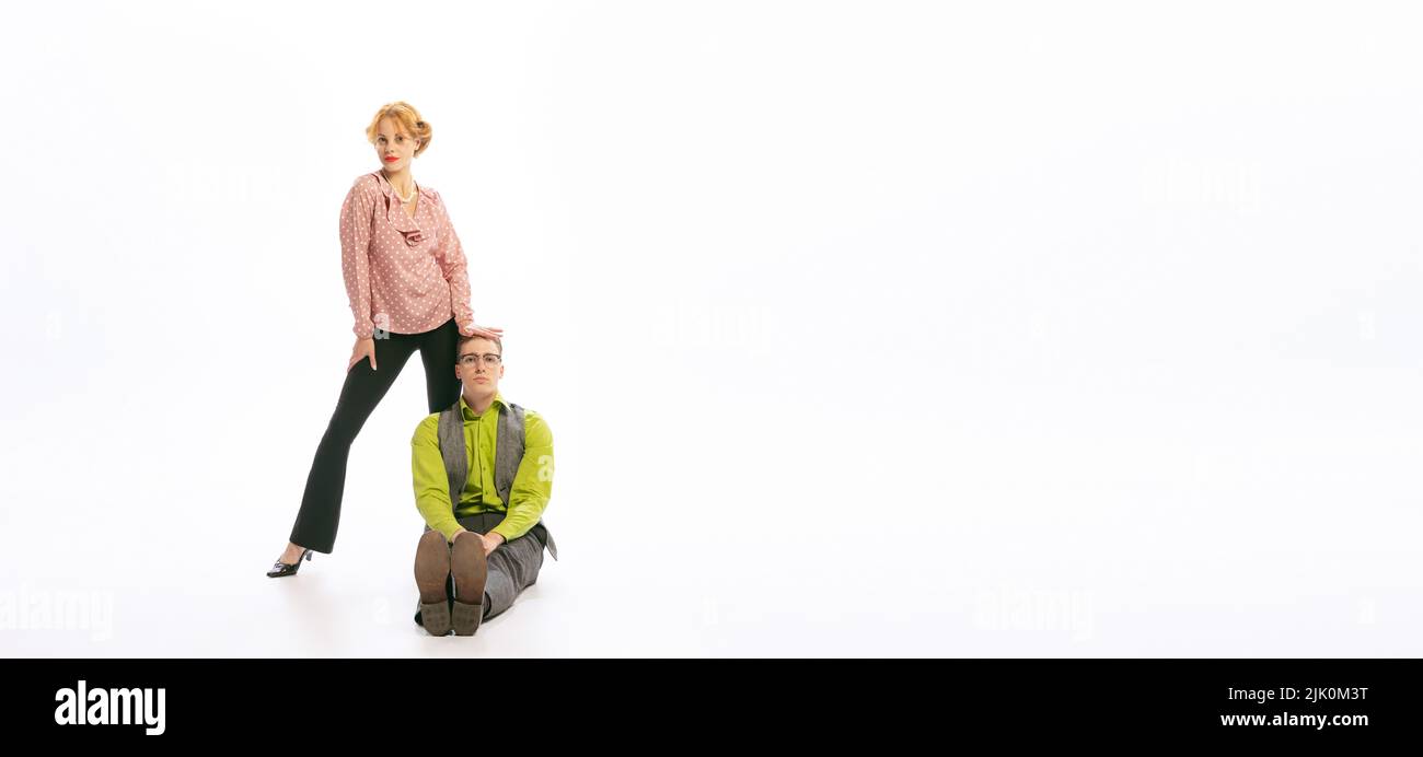 Portrait of stylish domineering woman with young man in a suit sitting ...