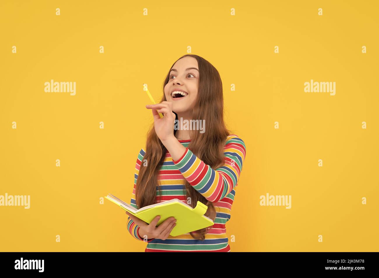 Happy kid genius got inspiration holding book and pointing pen up ...
