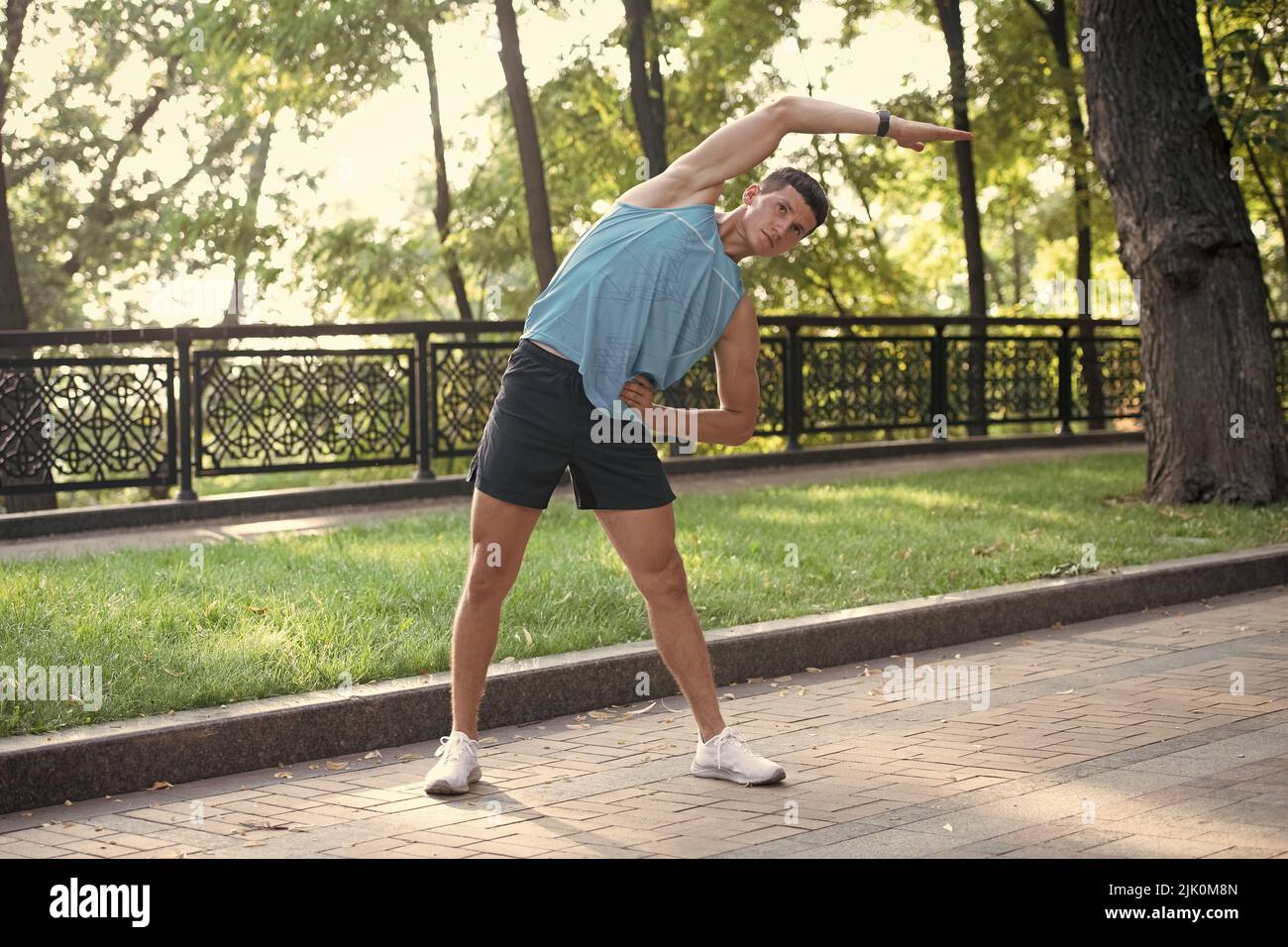 active man in sportswear making warm up exercise Stock Photo - Alamy