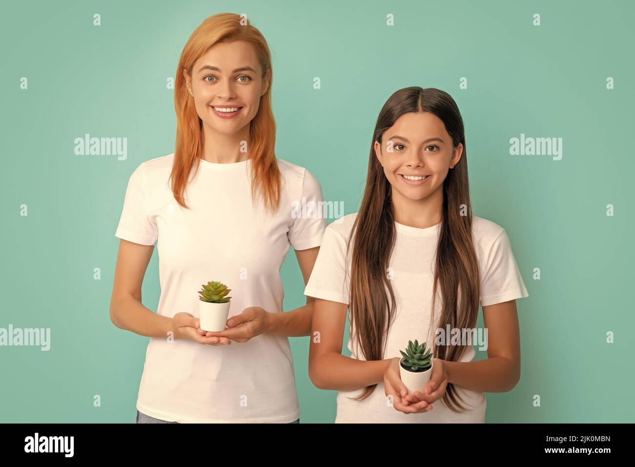 Happy woman mother and daughter child smile holding pot plants blue ...