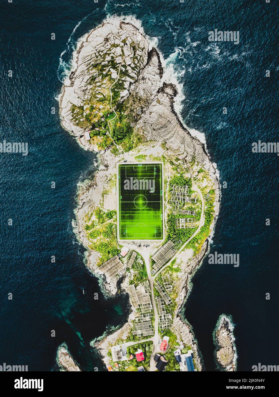 An aerial top view of a small island with a football field in the ...