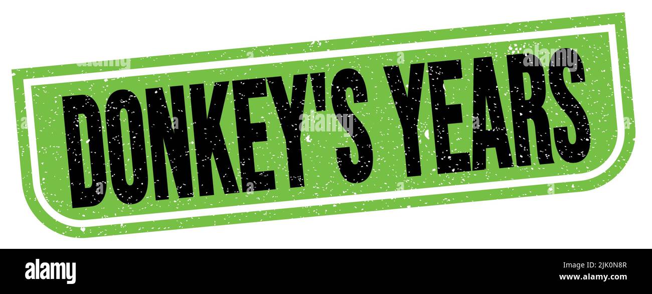 DONKEY'S YEARS text written on green-black grungy stamp sign Stock ...