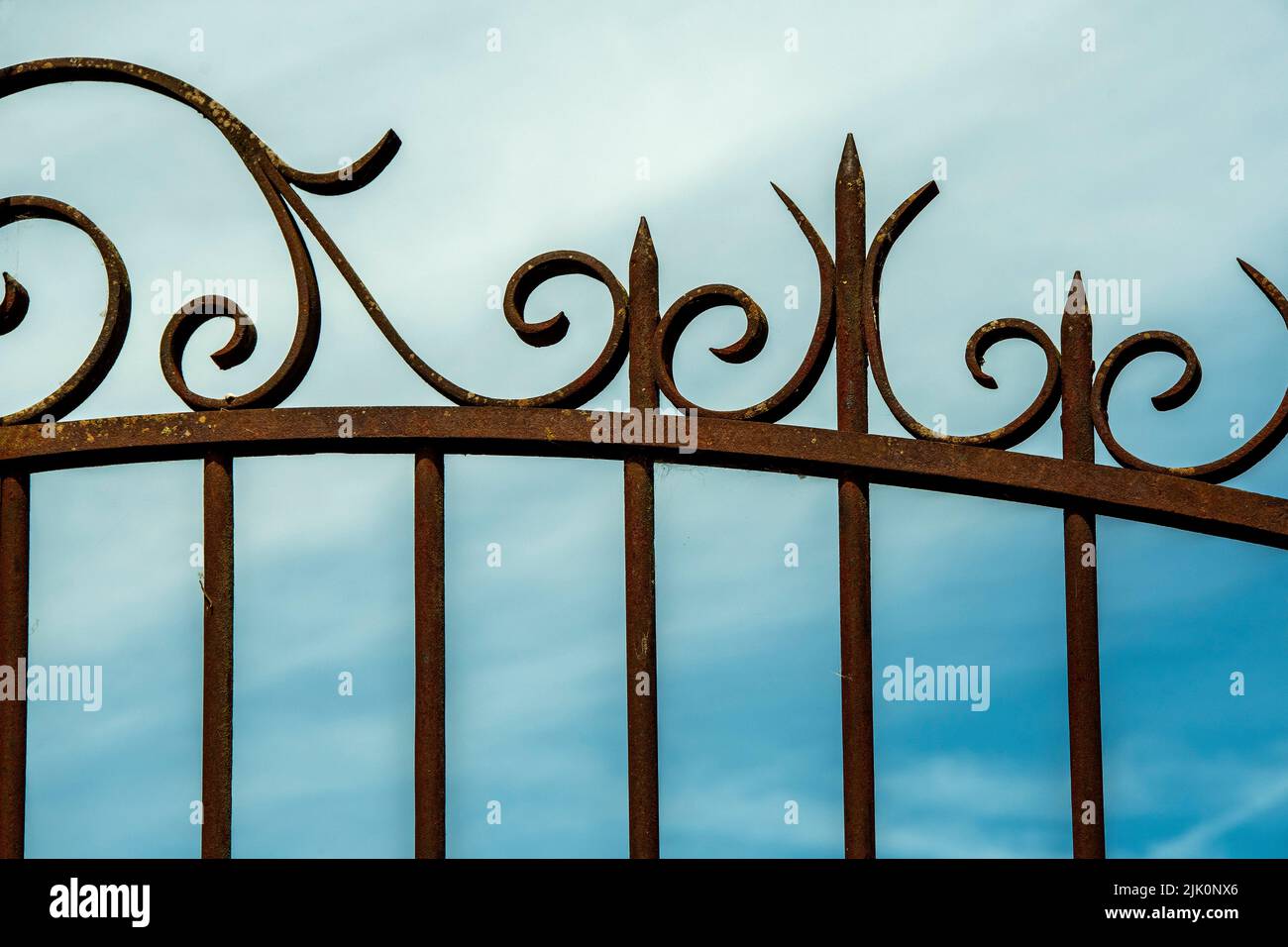A close-up view of a wrought iron fence featuring ornate curly designs ...
