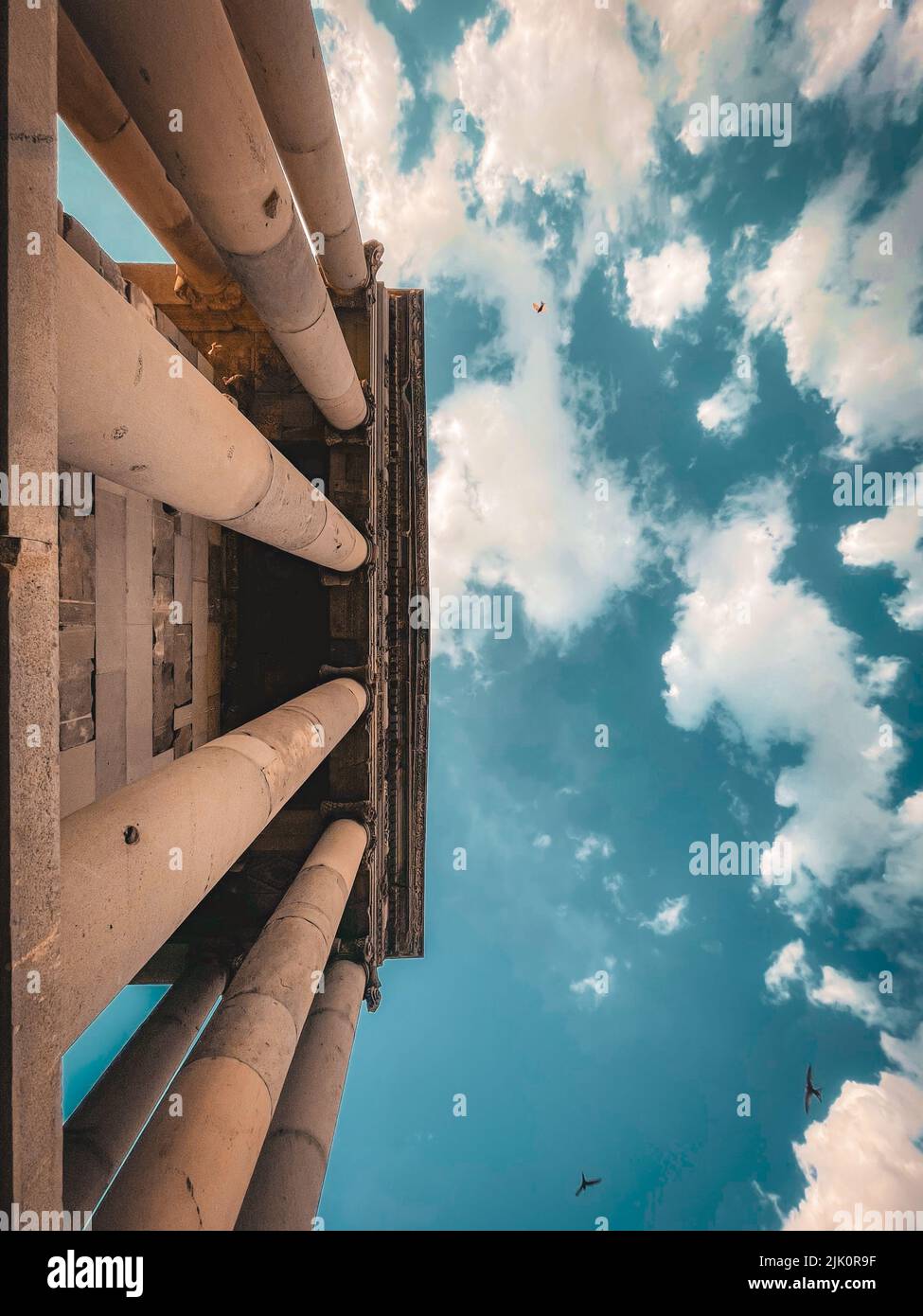 A vertical shot of a huge columns of an ancient Hellenic temple with a ...