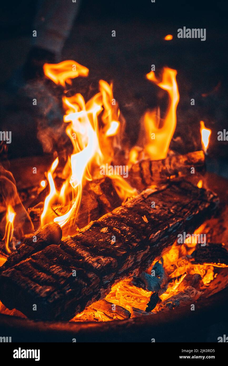 A vertical shot of a bonfire burning in a metallic bowl at night Stock ...