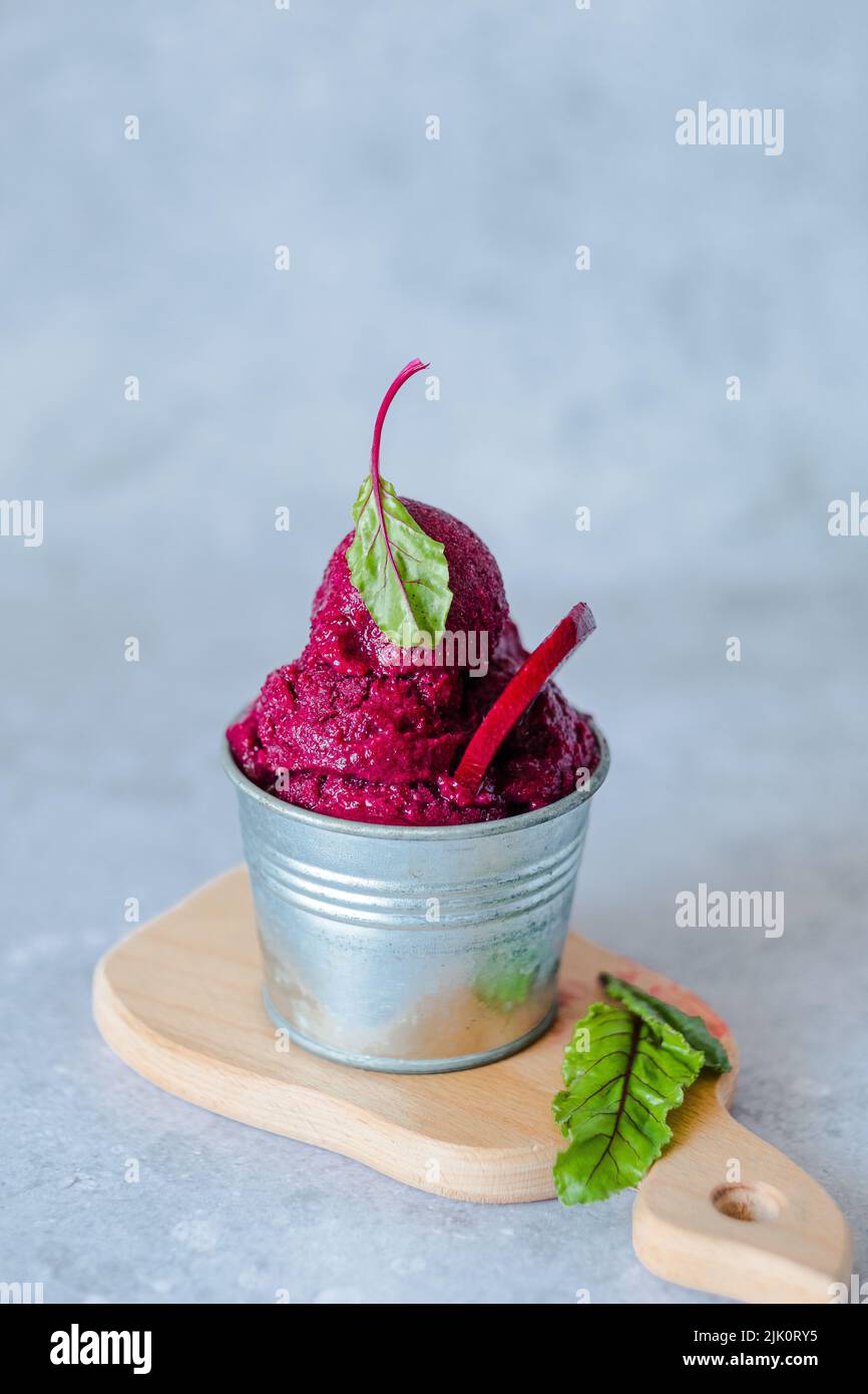 Beetroot vegan sorbet in a metal vessel on a gray background. Healthy ...