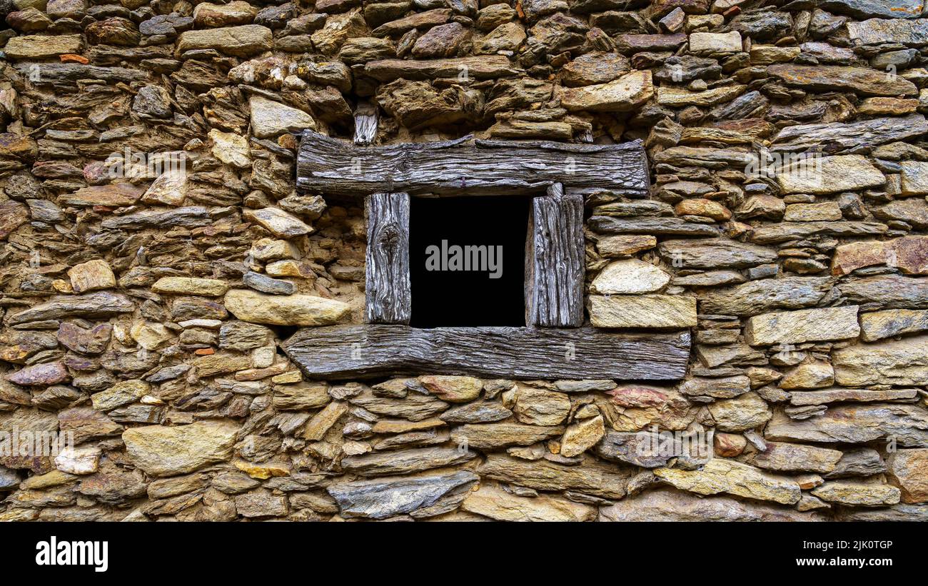 Small wooden window in traditional wall made of stone, stone texture ...