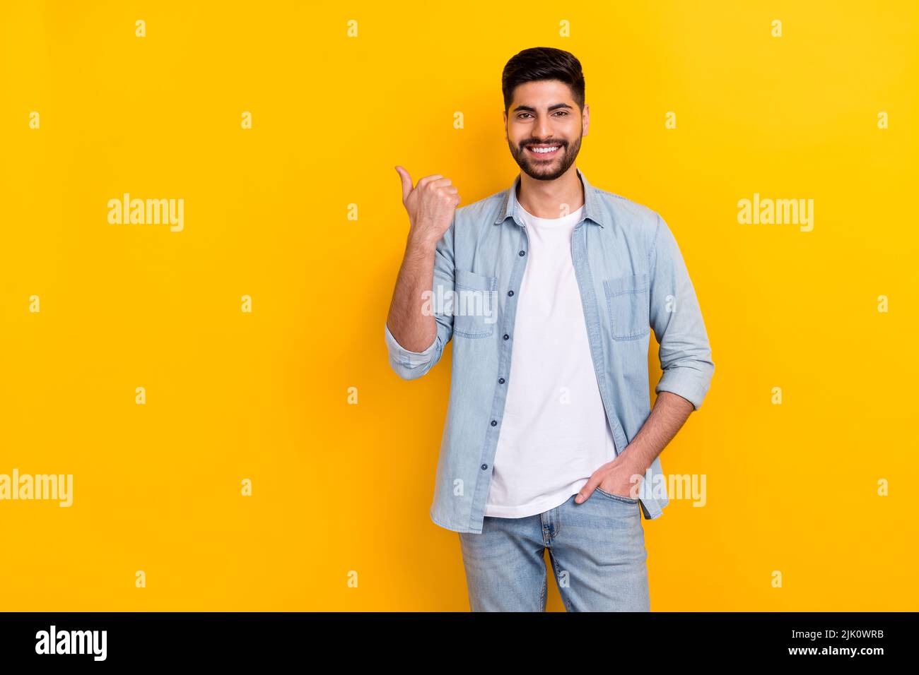 Photo of handsome guy pointing finger empty space promoting new product ...