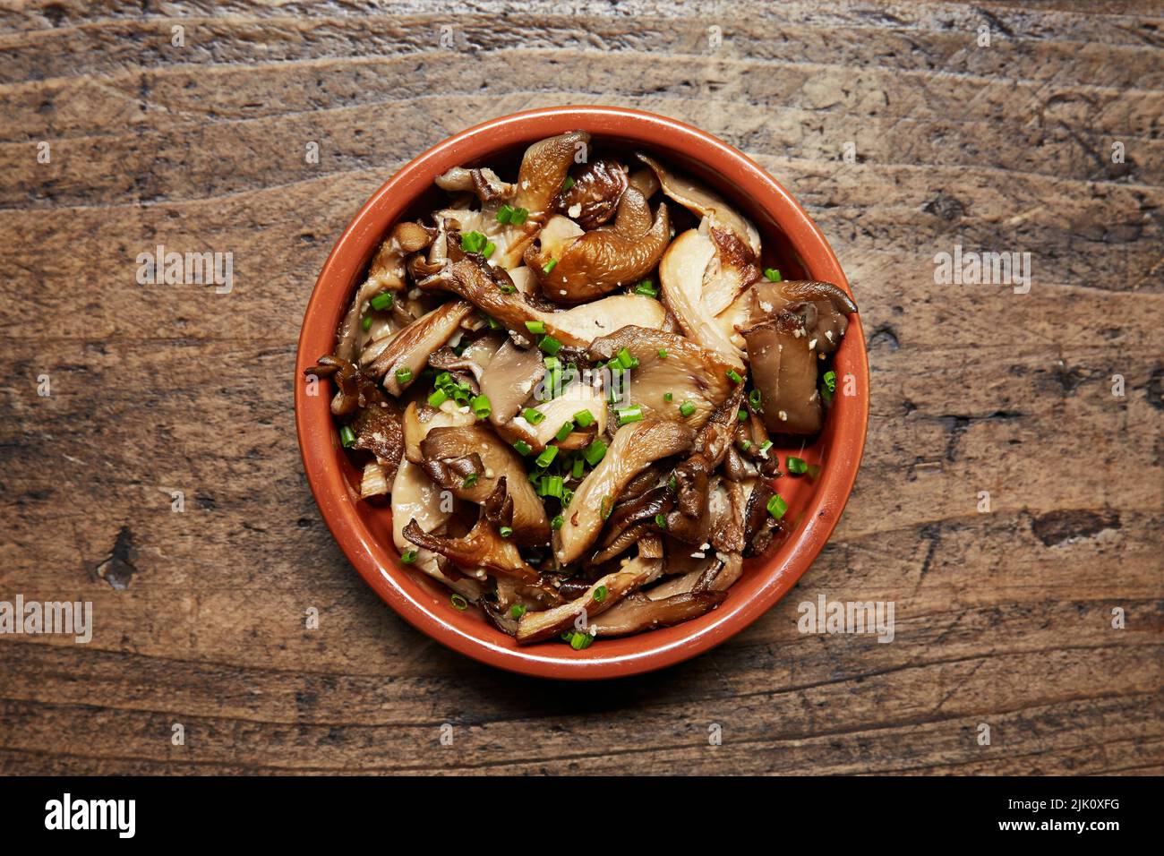 Mushrooms and chives in a terracotta tapas dish Stock Photo - Alamy