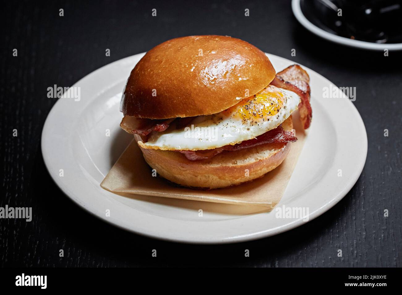 Egg and bacon brioche breakfast bap Stock Photo - Alamy