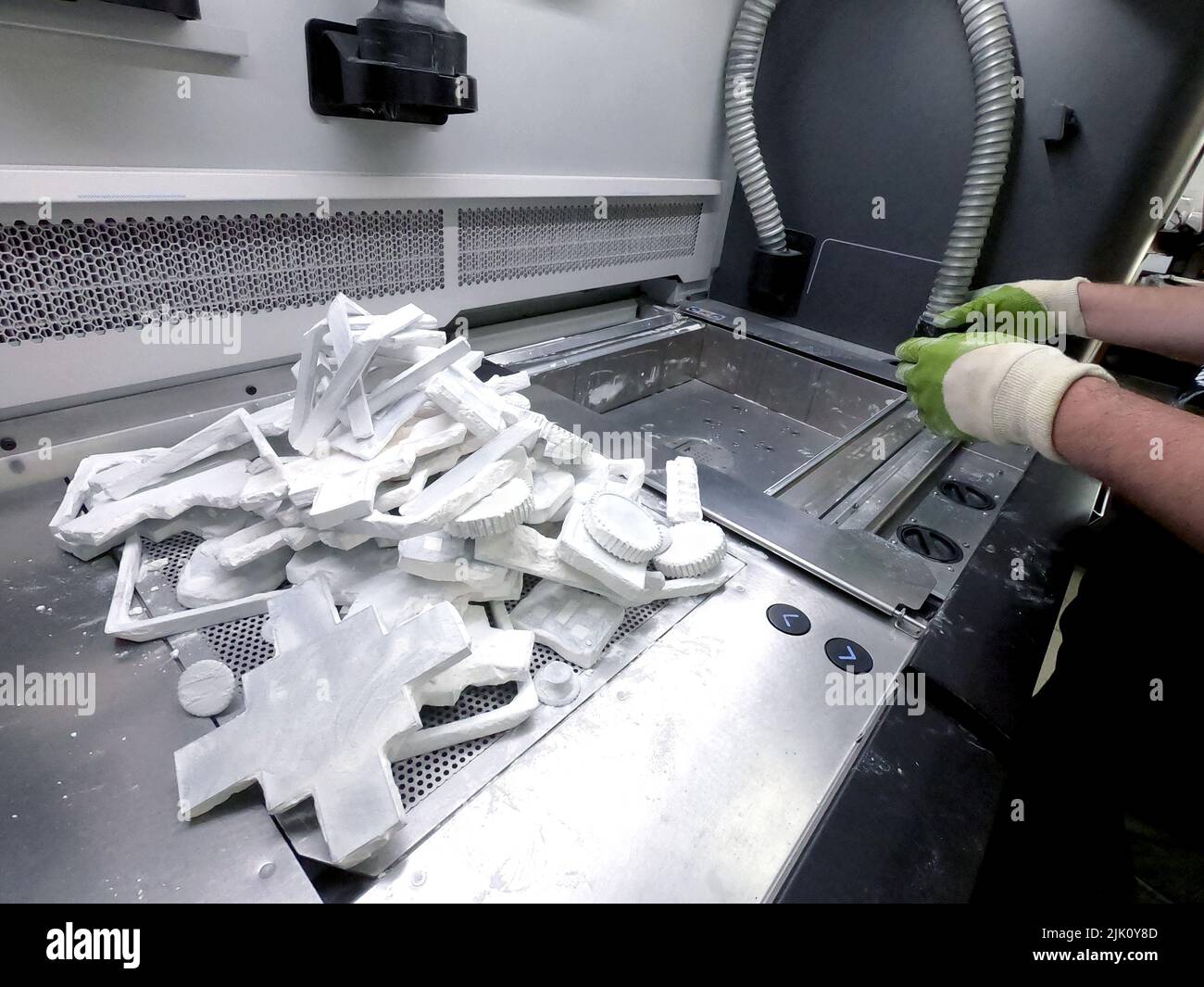 Man cleans details printed on industrial 3D printer from white plastic ...