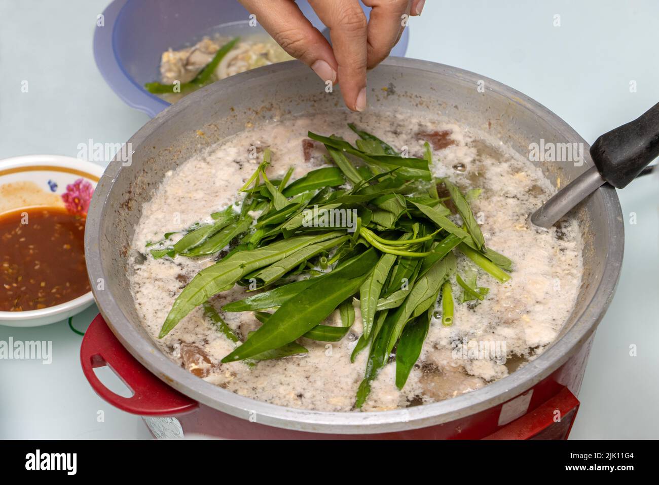 Preparing traditional Suki soup by cooking in a pot Stock Photo - Alamy