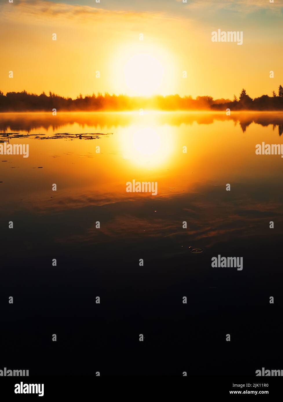 The first minutes of sunrise over the river, the sun disc appeared from ...