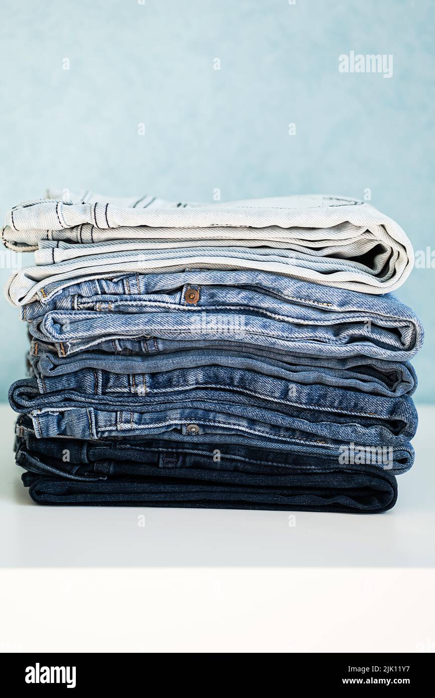 Some stacked blue jeans, close up. Denim collection Stock Photo - Alamy