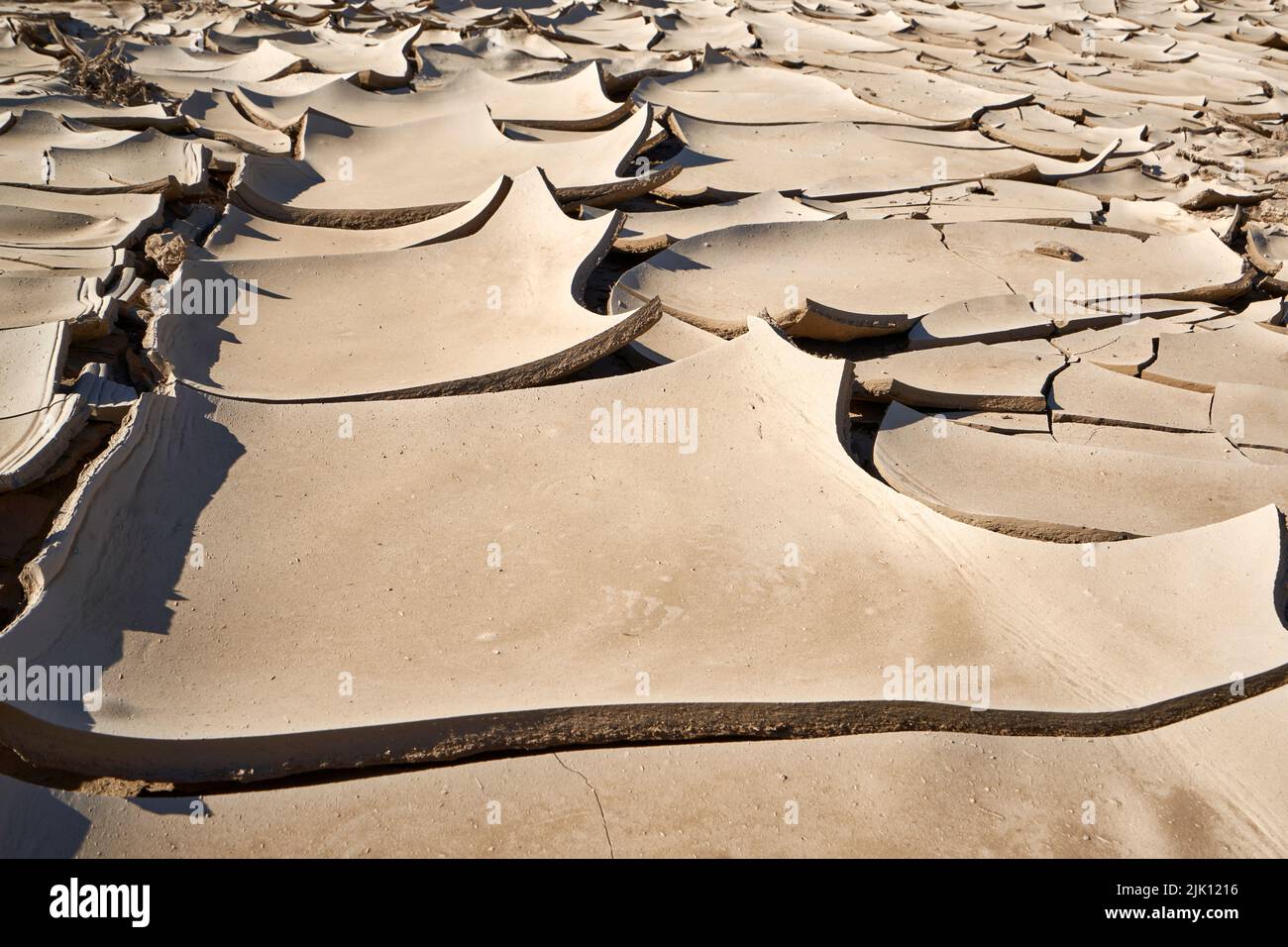 Abstract pattern of dry, cracked clay mud in dried-up river bed caused ...
