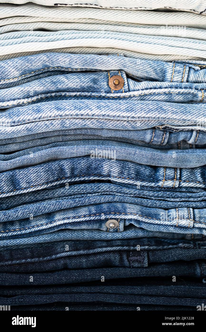 Some stacked blue jeans, close up. Denim collection Stock Photo - Alamy