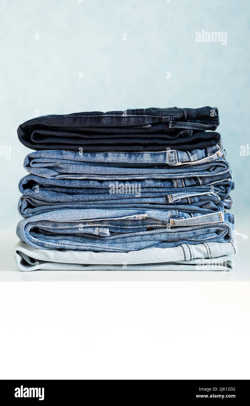 Some stacked blue jeans, close up. Denim collection Stock Photo - Alamy