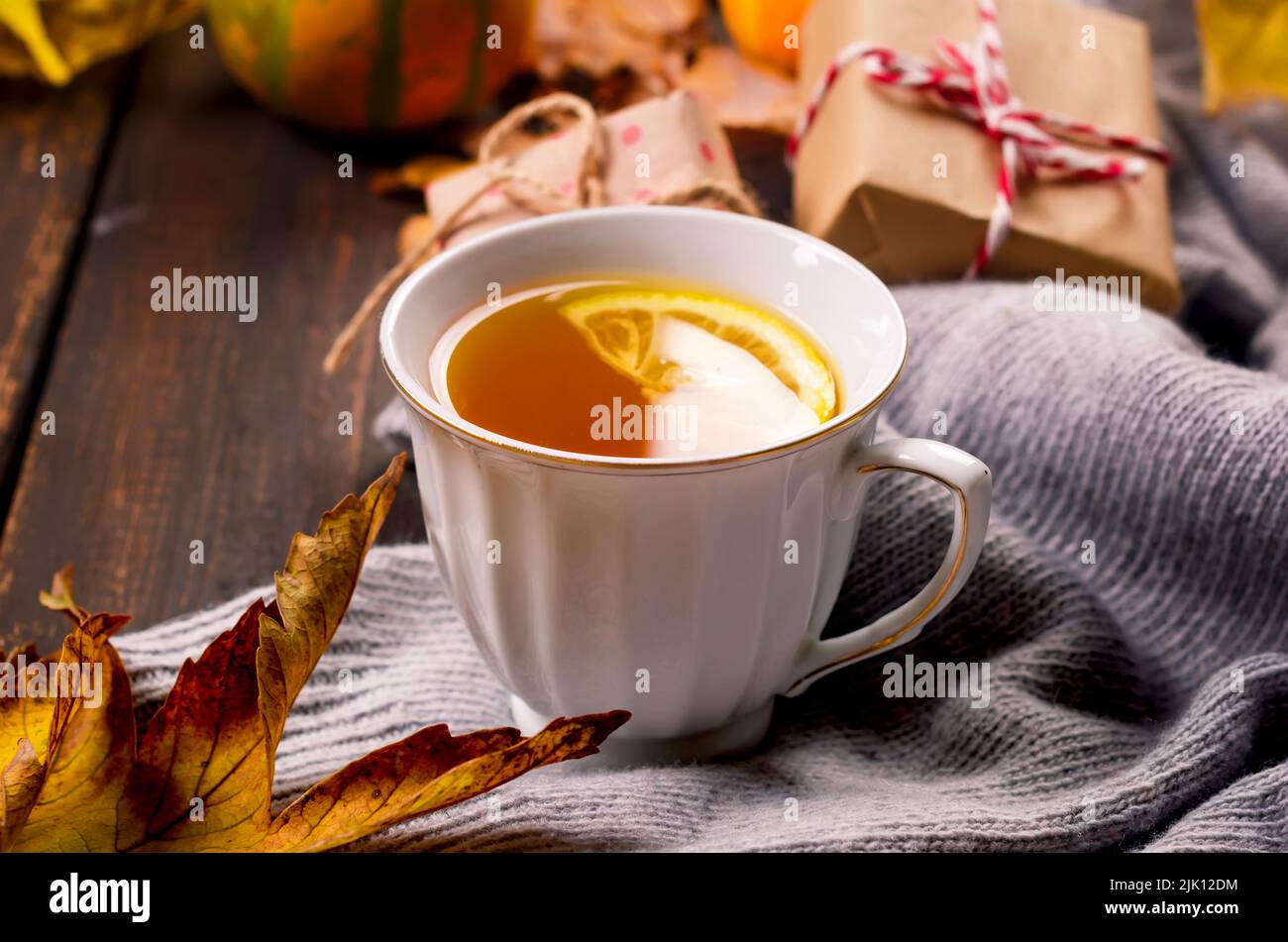 Autumn still life. Hot tea with lemon, yellow maple leaves and cozy ...