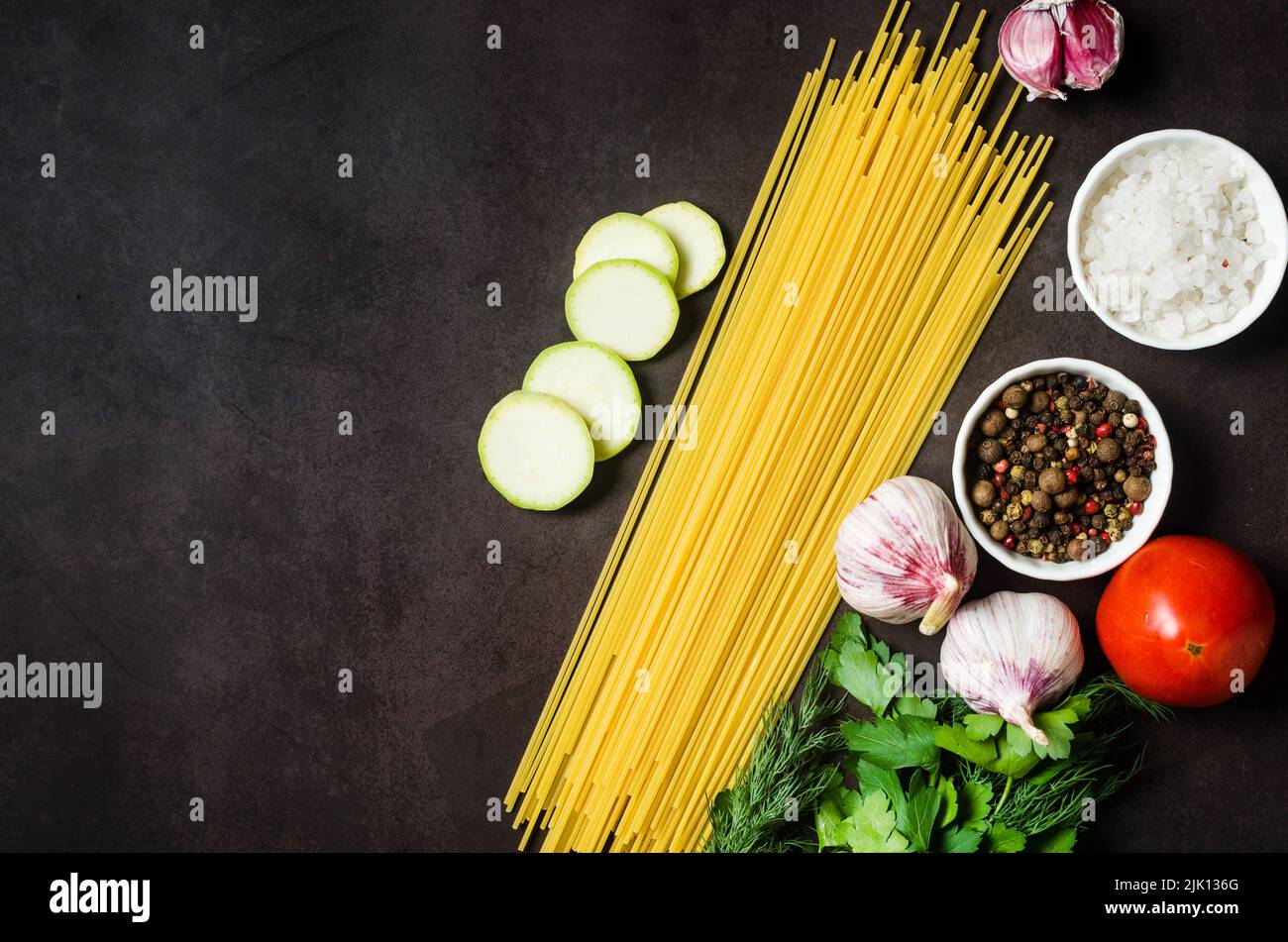 Raw long spaghetti with ingredients for cooking, marrow, tomatoes ...