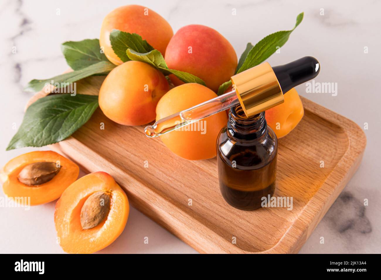 an open bottle with a dropper of cosmetic organic oil apricot on a tray ...