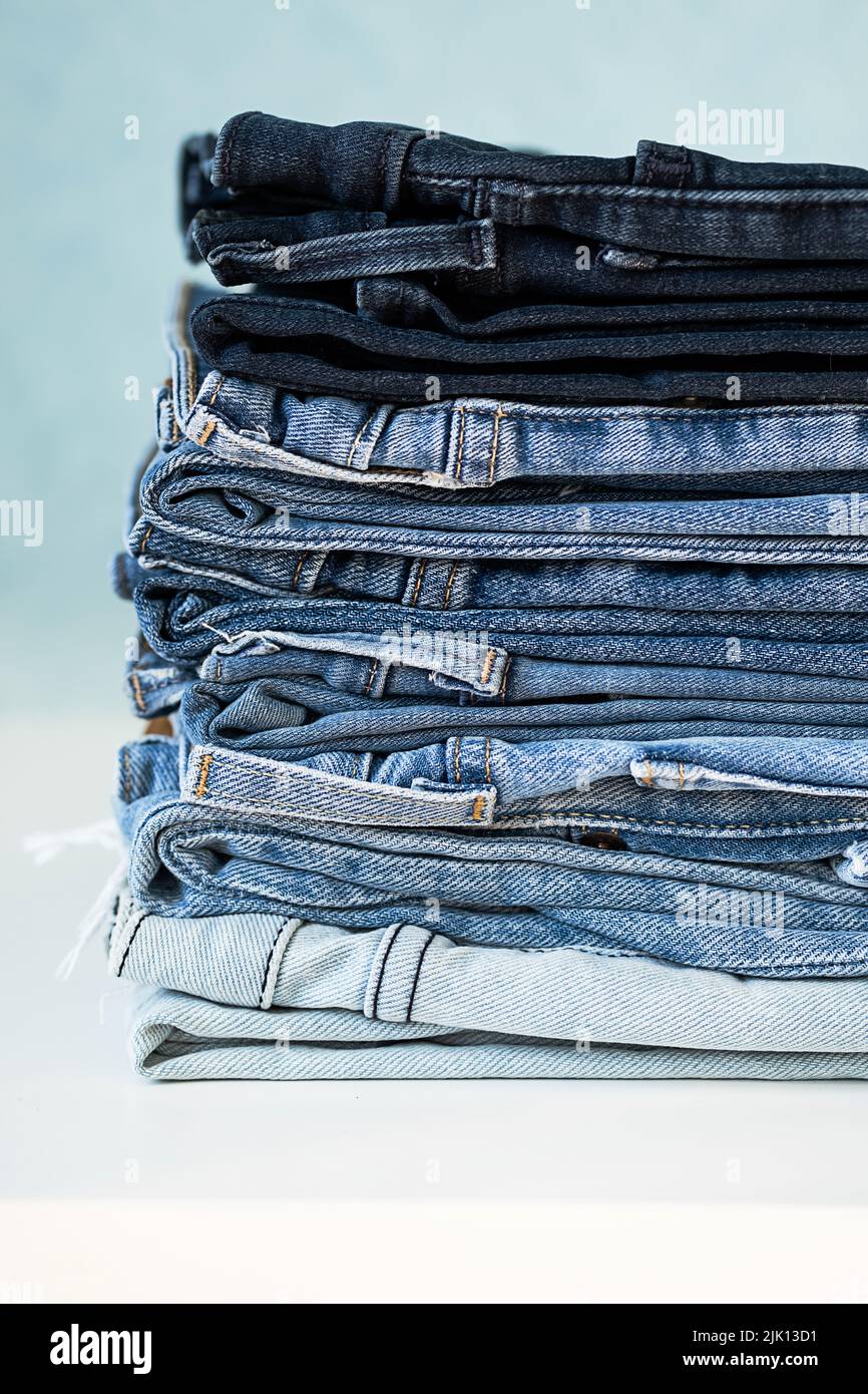 Some stacked blue jeans, close up. Denim collection Stock Photo - Alamy