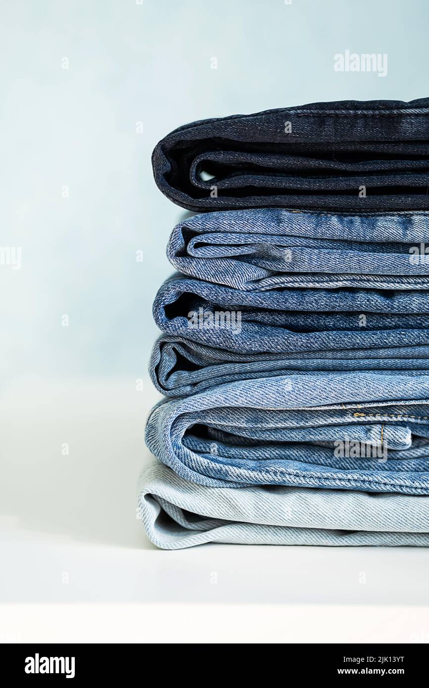 Some stacked blue jeans, close up. Denim collection Stock Photo - Alamy