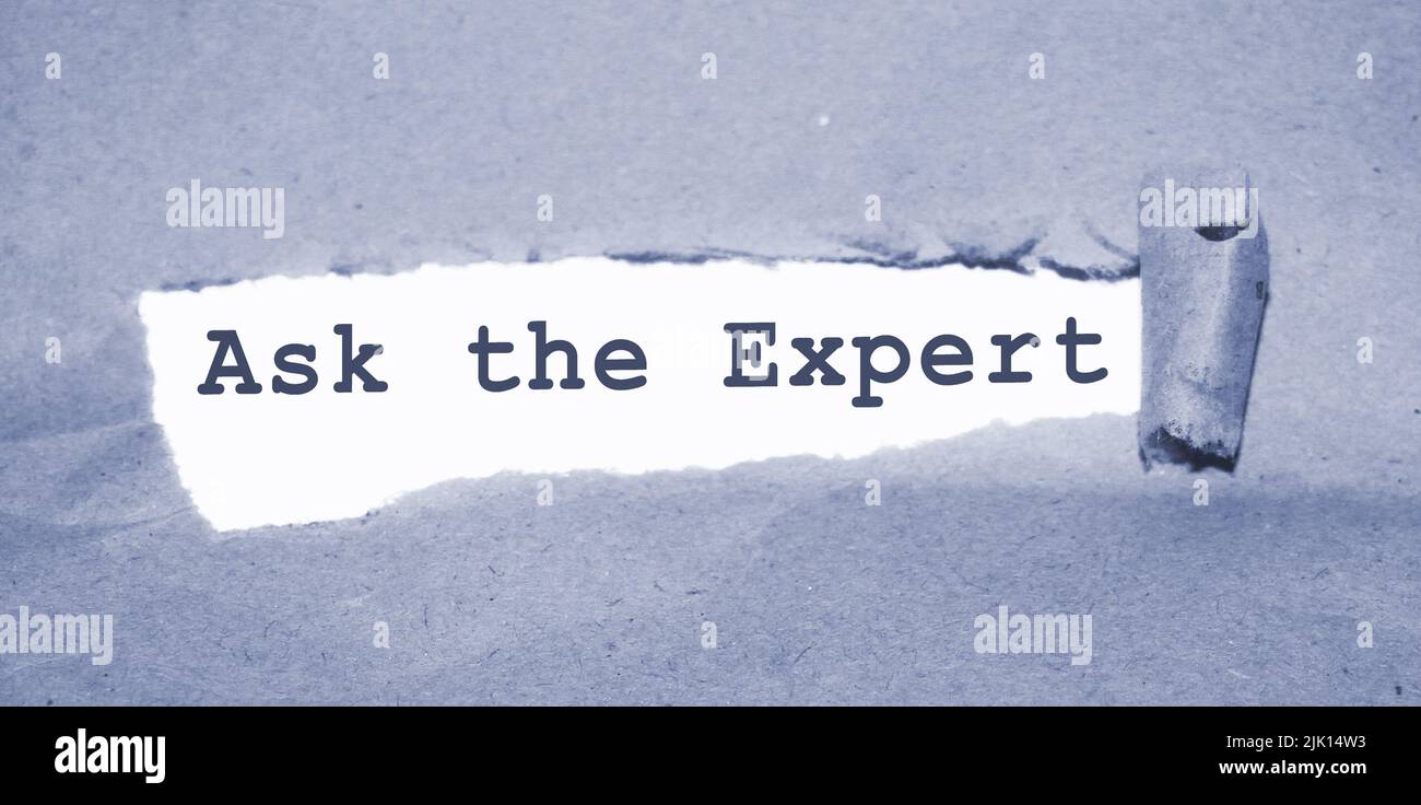 The text ASK AN EXPERT appearing behind torn brown paper. Professional ...
