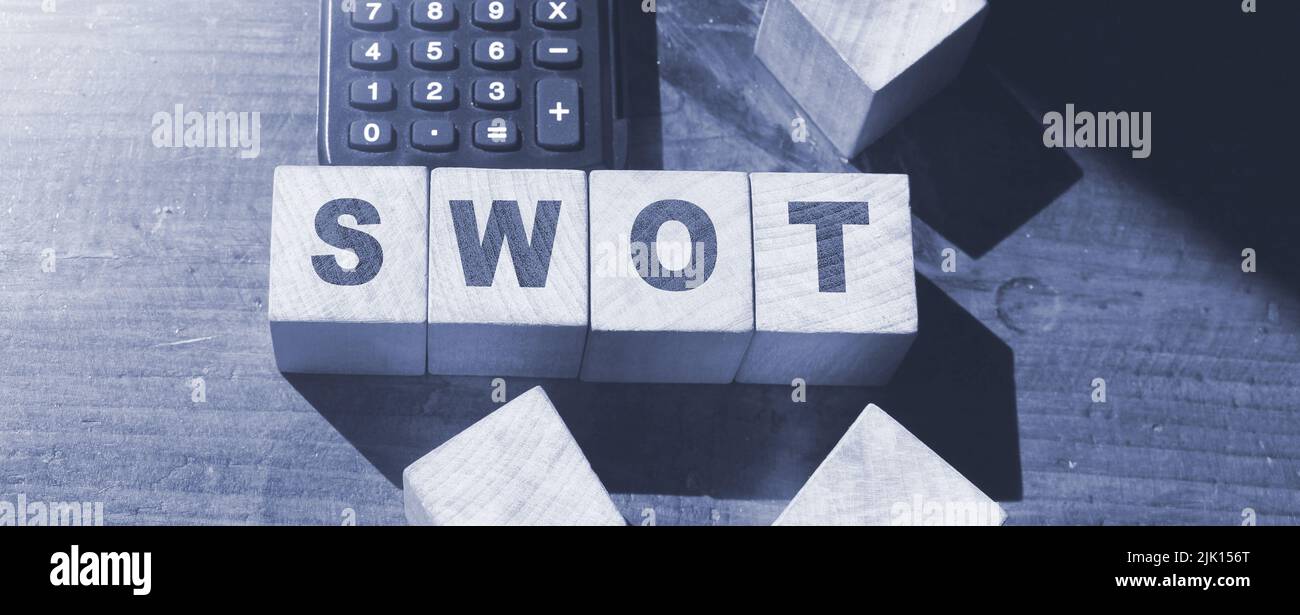 swot word made with building blocks,, calculator on wooden table ...