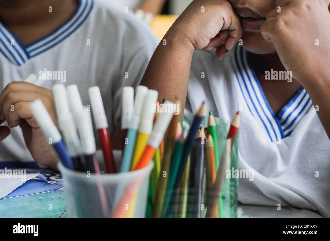 Detail of student hands painting writing with colored pencils. Salvador ...