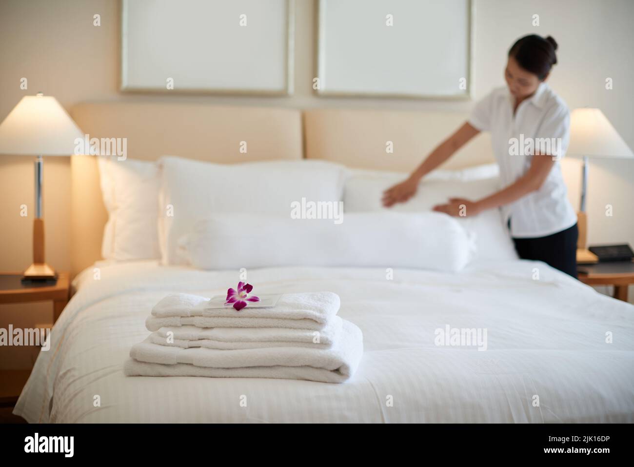 Maid cleaning bedroom after guests, focus of clean towels Stock Photo ...