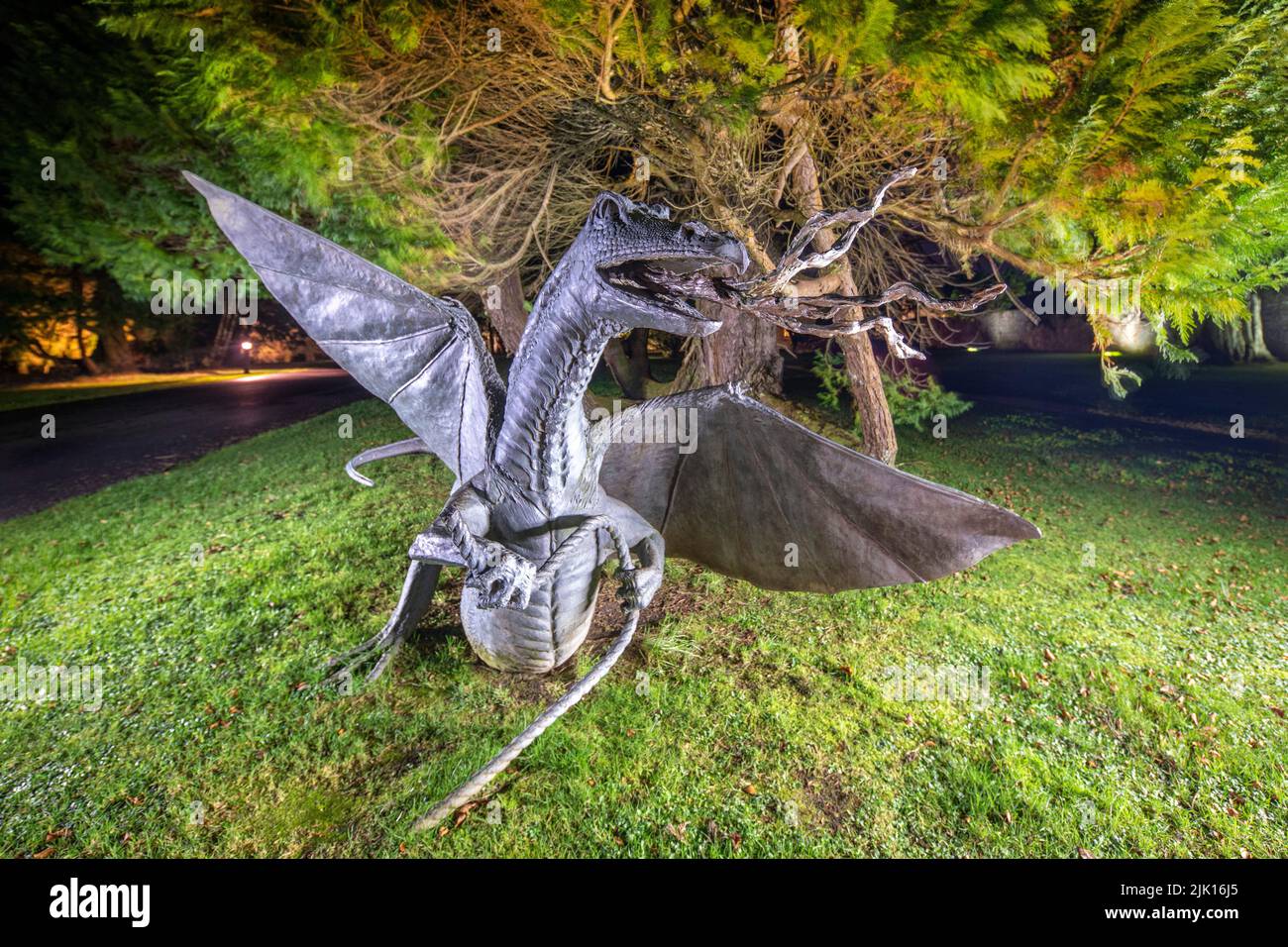 An old statue of a dragon with wings in a park at night Stock Photo - Alamy