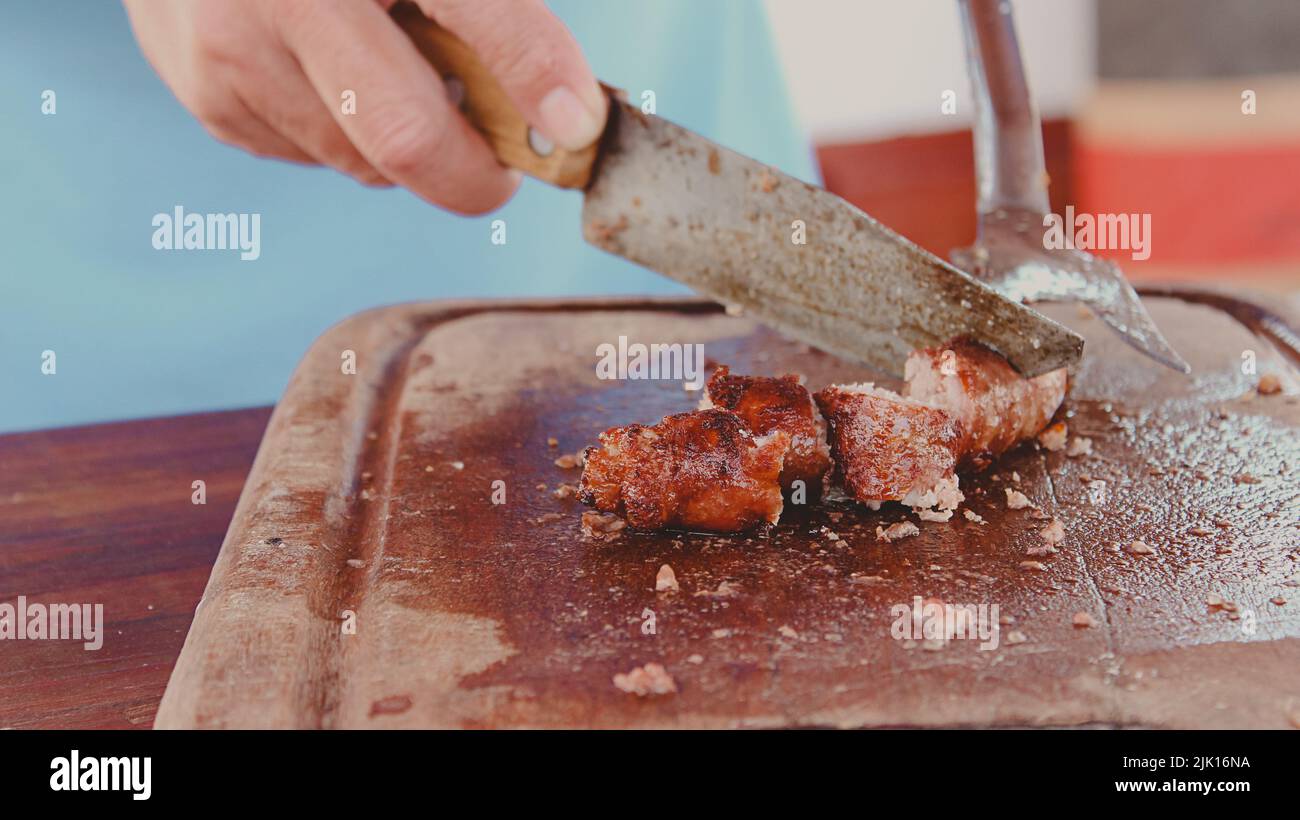 person cutting barbecue meat Stock Photo - Alamy